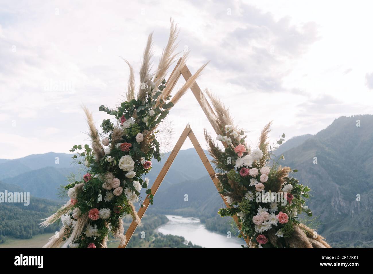 Wedding arch in the shape of a triangle with flowers Stock Photo - Alamy
