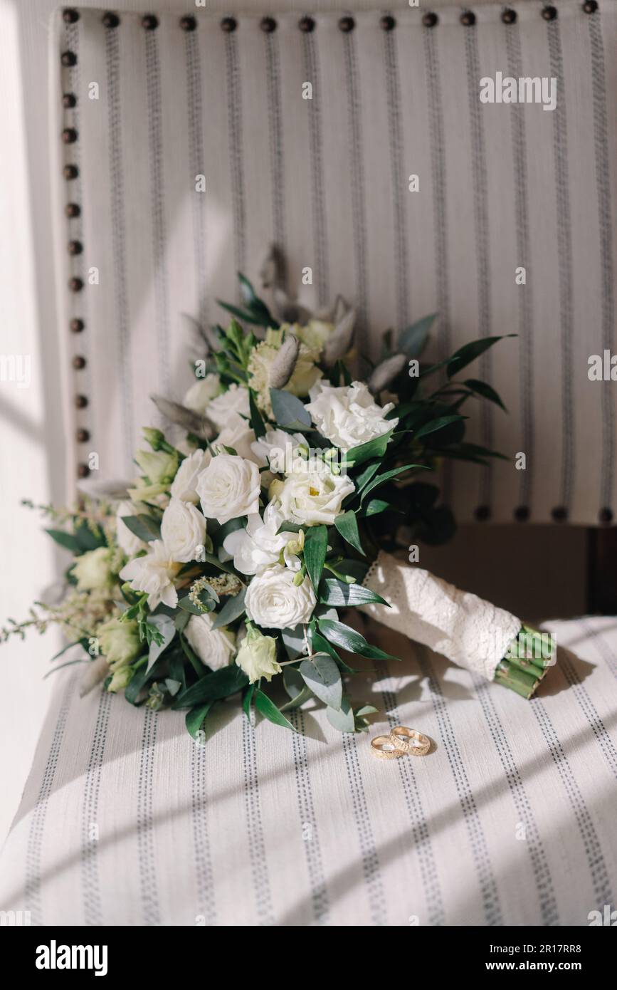 Wedding rings and bridal bouquet on a chair Stock Photo - Alamy