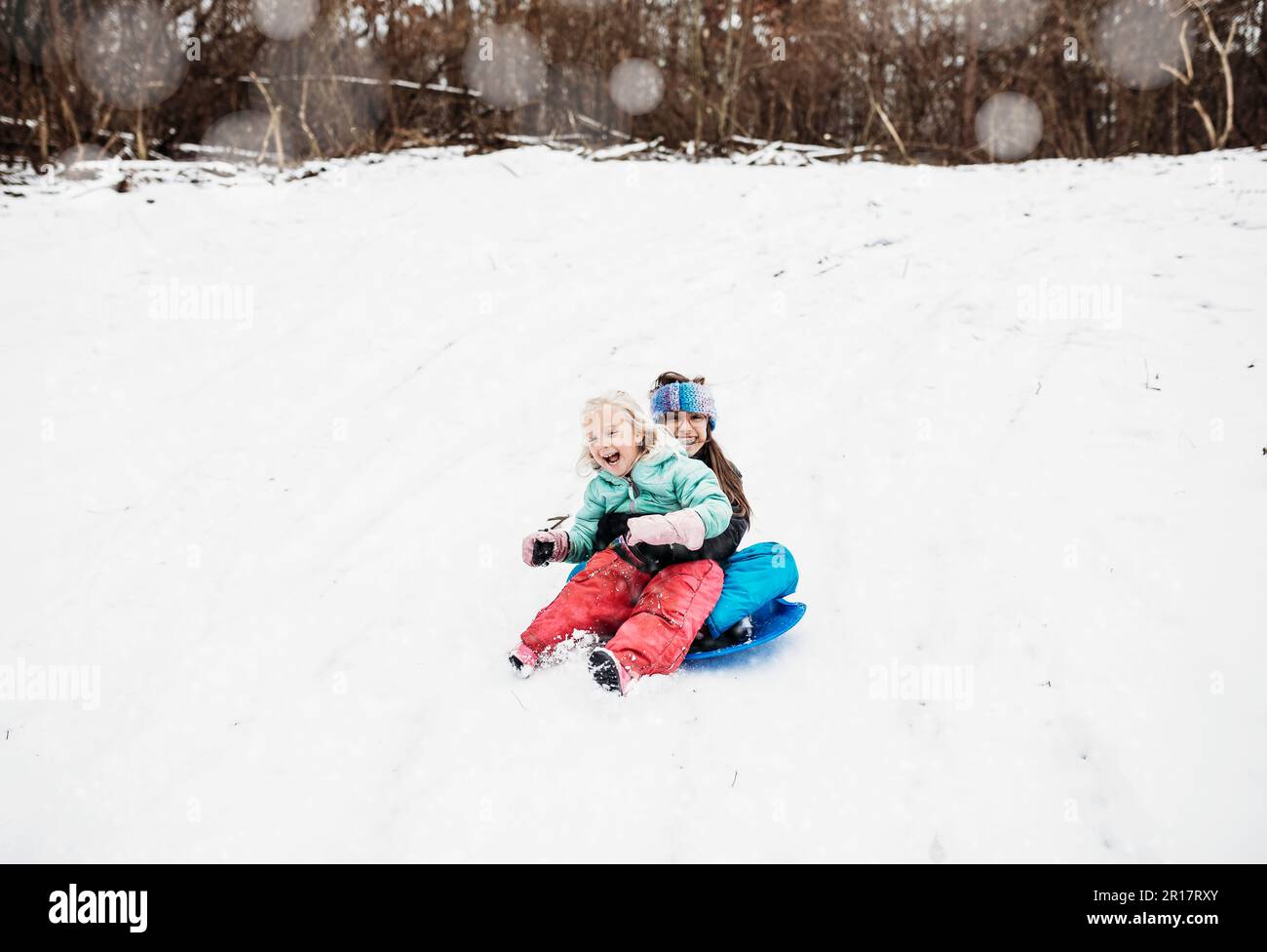 two girls sledding in snow in Northwest Indiana Stock Photo - Alamy