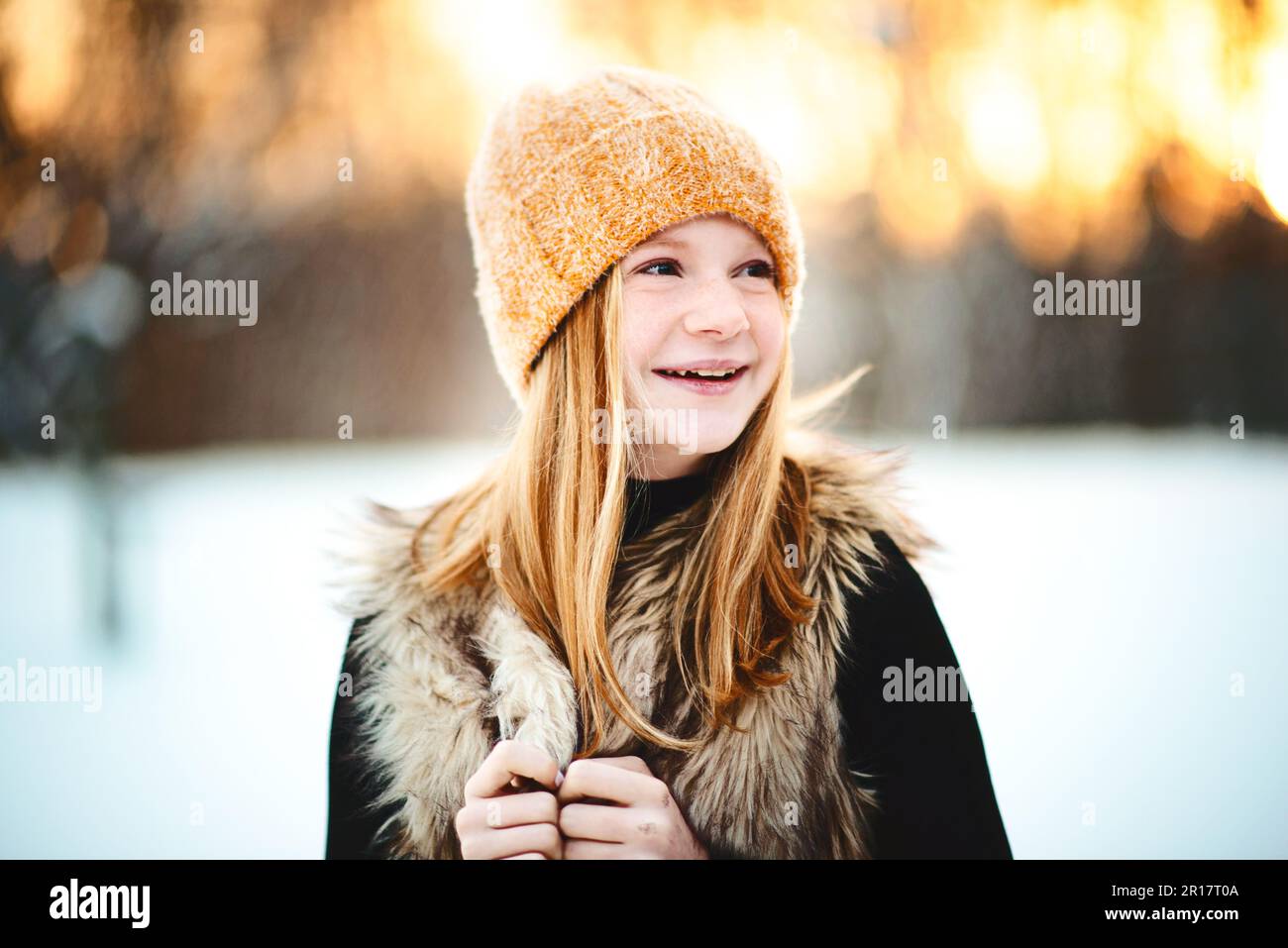 Happy tween girl with yellow hat outdoors on golden winter day Stock ...