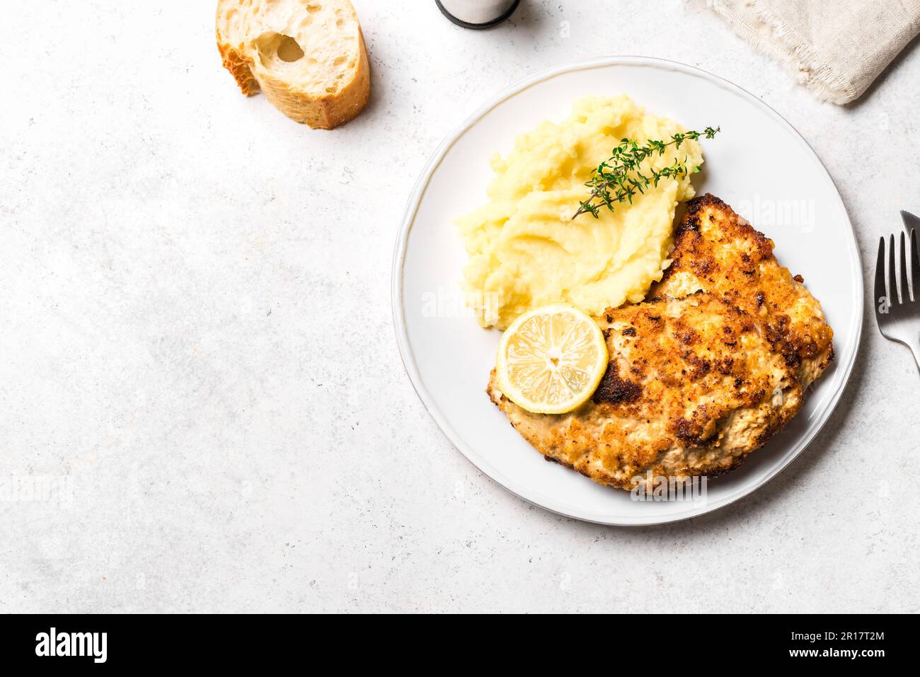 German schnitzel with fresh mashed potatoes and thyme on white ...