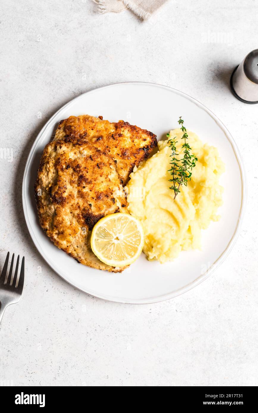 German schnitzel with fresh mashed potatoes on white background, copy ...