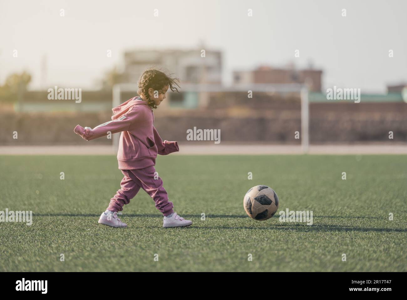 Sports kid. Happy little girl kid kicking a soccer ball, Child plays ...