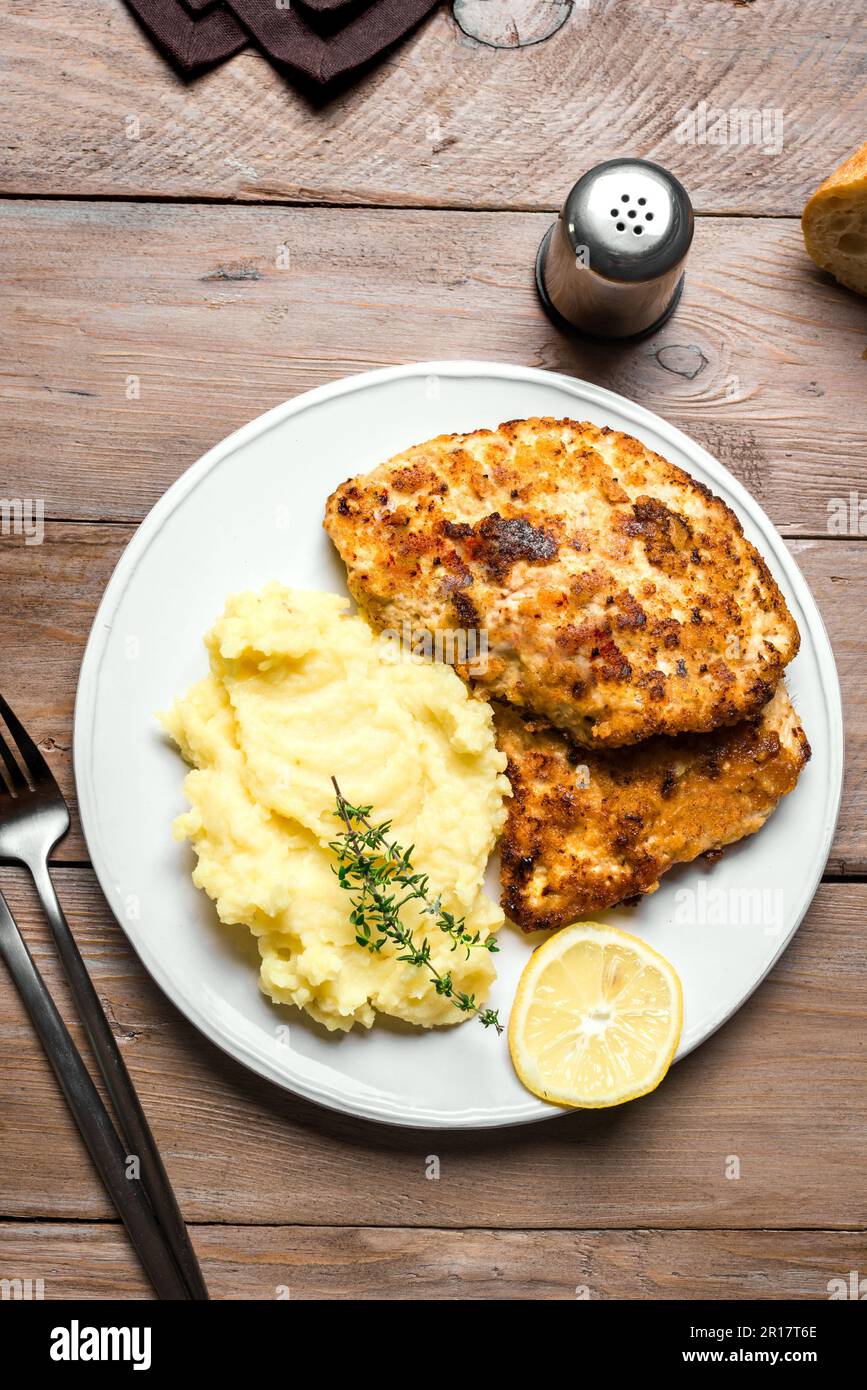 German schnitzel with fresh mashed potatoes on wooden table. Homemade ...