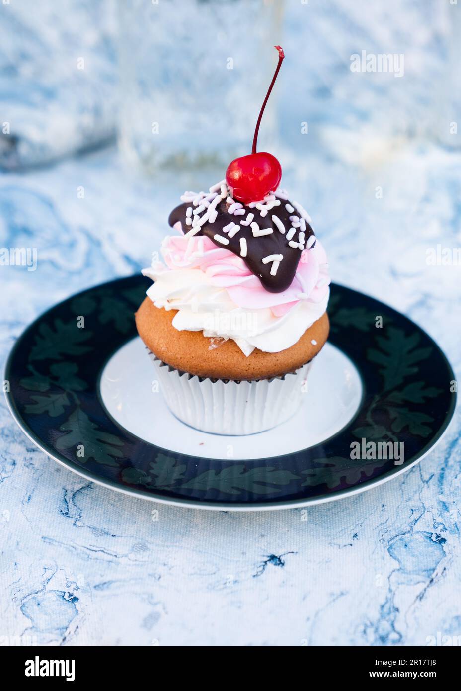 Frosted cupcake with cherry on top Stock Photo - Alamy