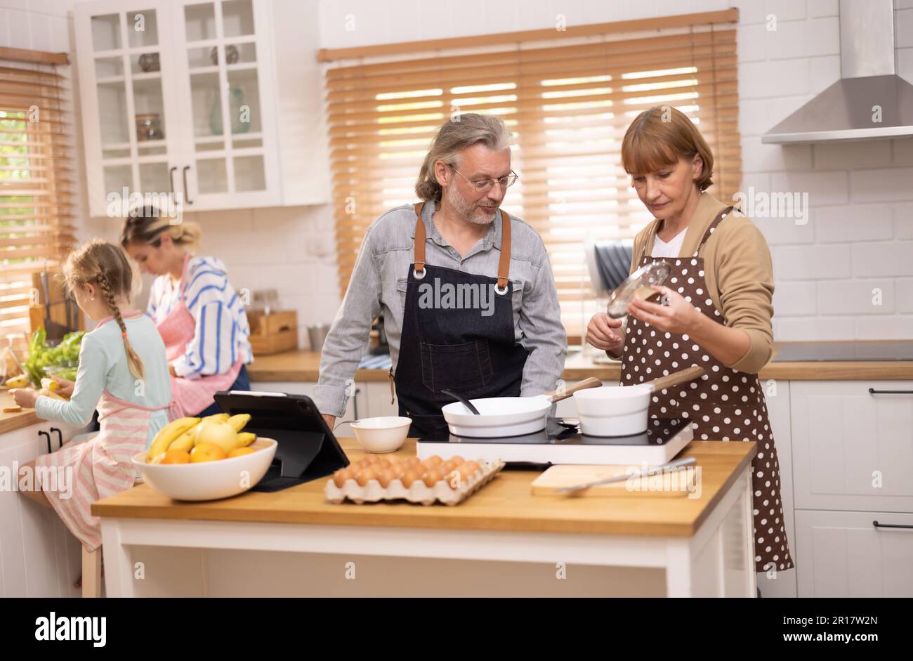 Multi-generational family members explore new and tasteful recipes on a ...