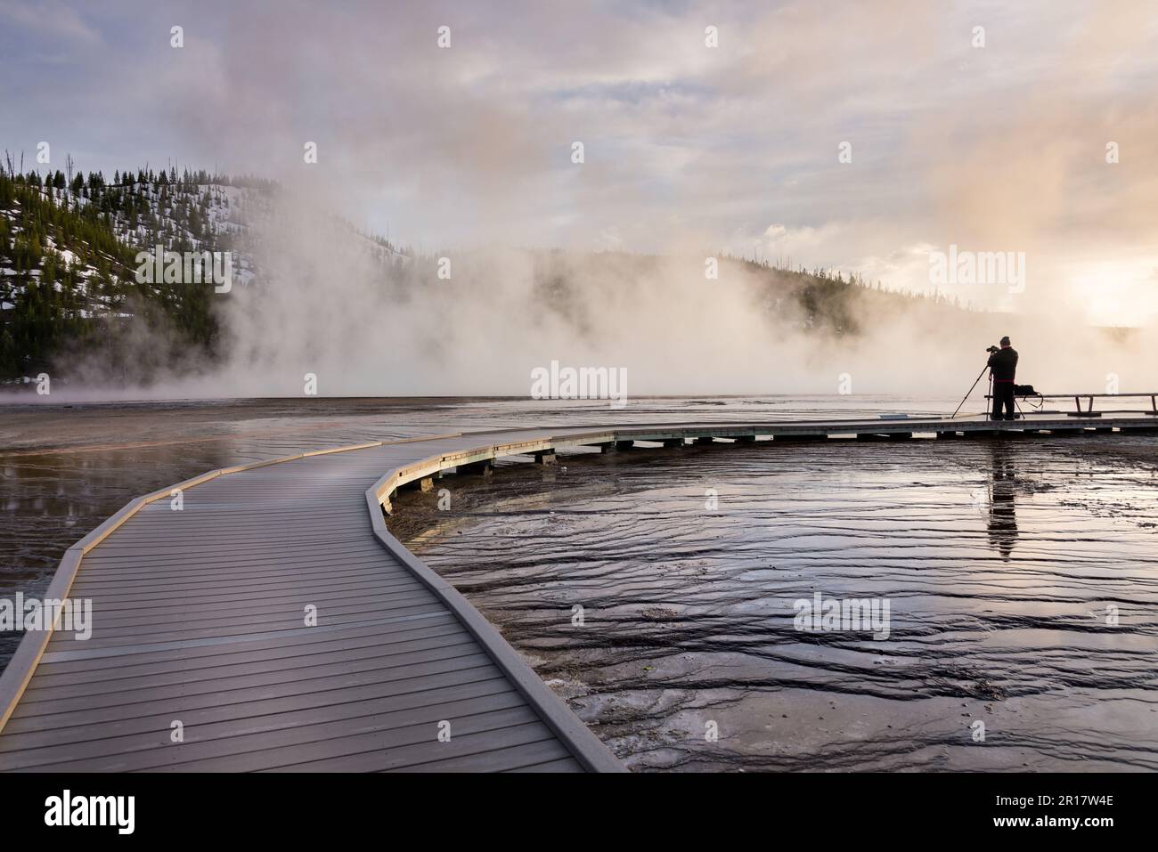 Photographer taking a picture at the Grand Prismatic Spring at dusk ...