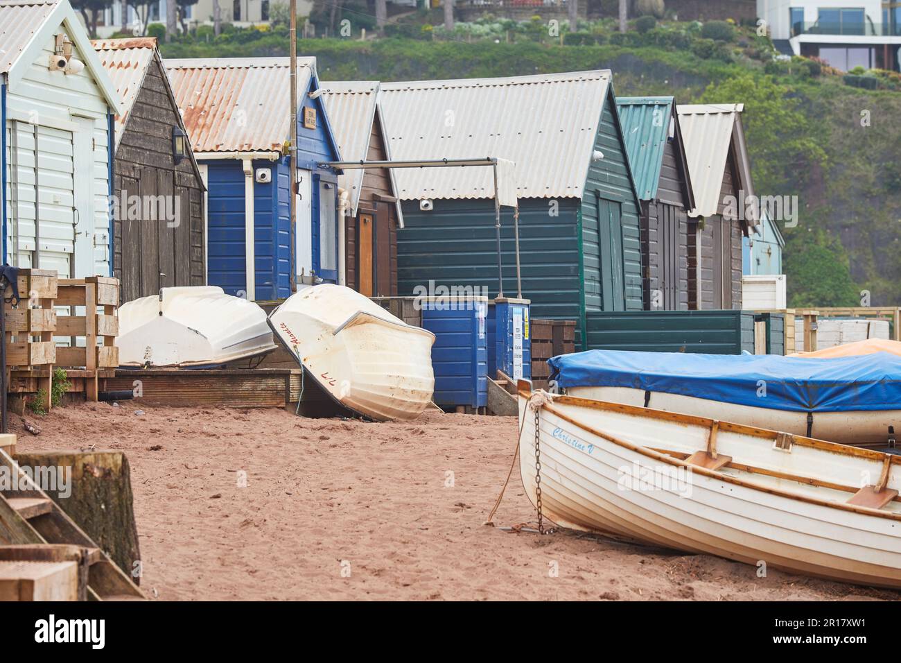 Boats, boat sheds and beach huts on the shore at Teignmouth, Devon ...