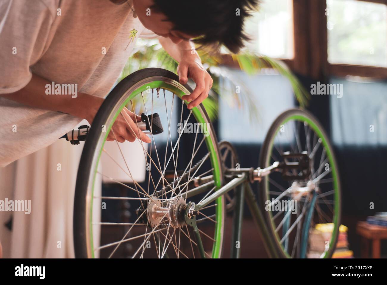 bike mechanic fixes wheel of green vintage bike in wooden studio Stock ...