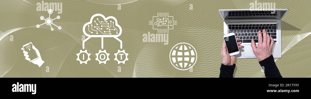 Top view of hands using laptop and mobile phone with symbol of iot ...