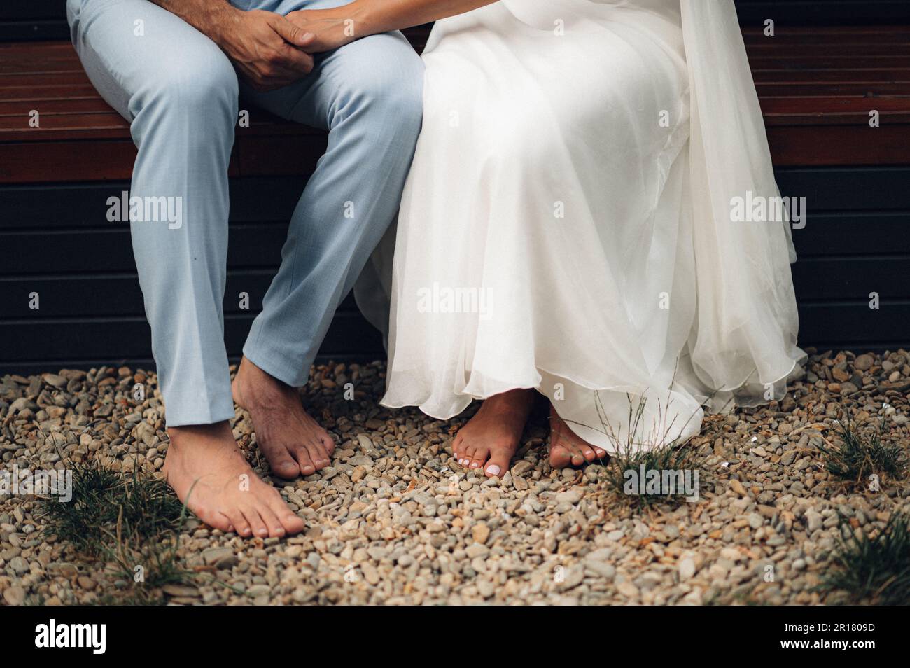 A newly married couple sitting on a bench barefoot Stock Photo - Alamy
