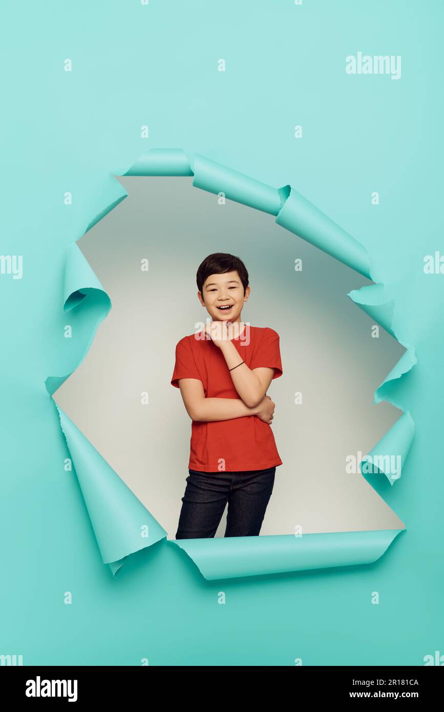 Happy asian preteen kid in red t-shirt looking at camera during World ...