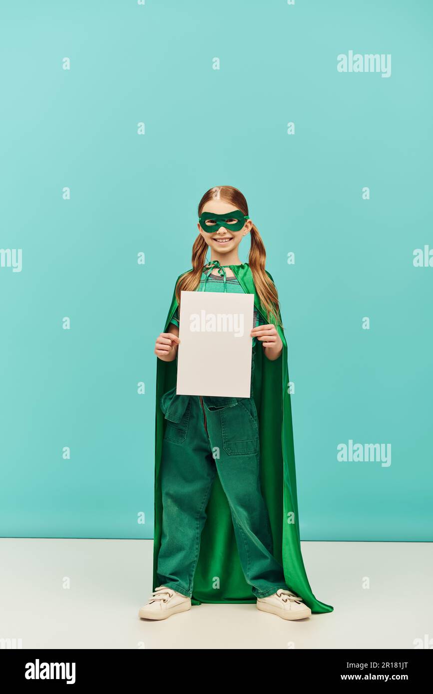 happy preteen girl in green superhero costume with cloak and mask ...
