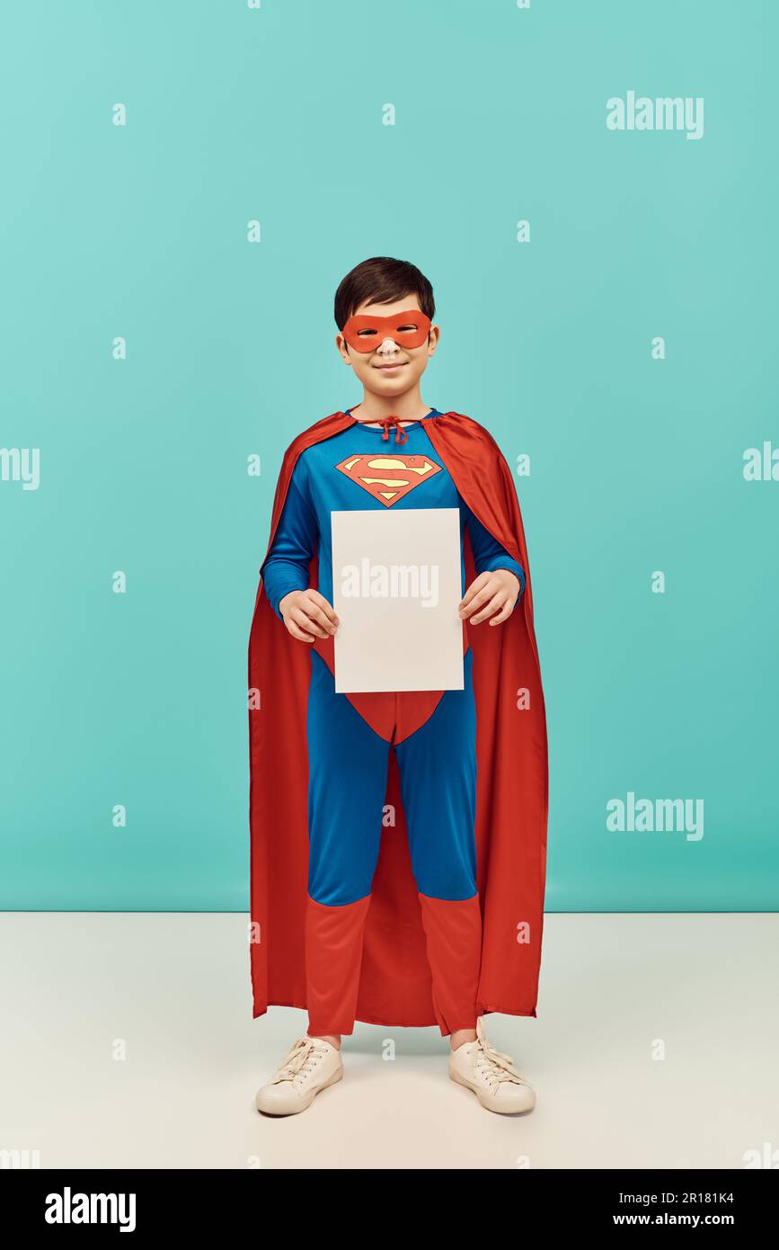 full length of preteen asian boy in superhero costume with mask and ...
