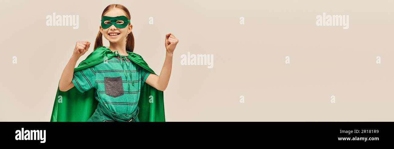 powerful kid in green superhero costume with cloak and mask on face ...