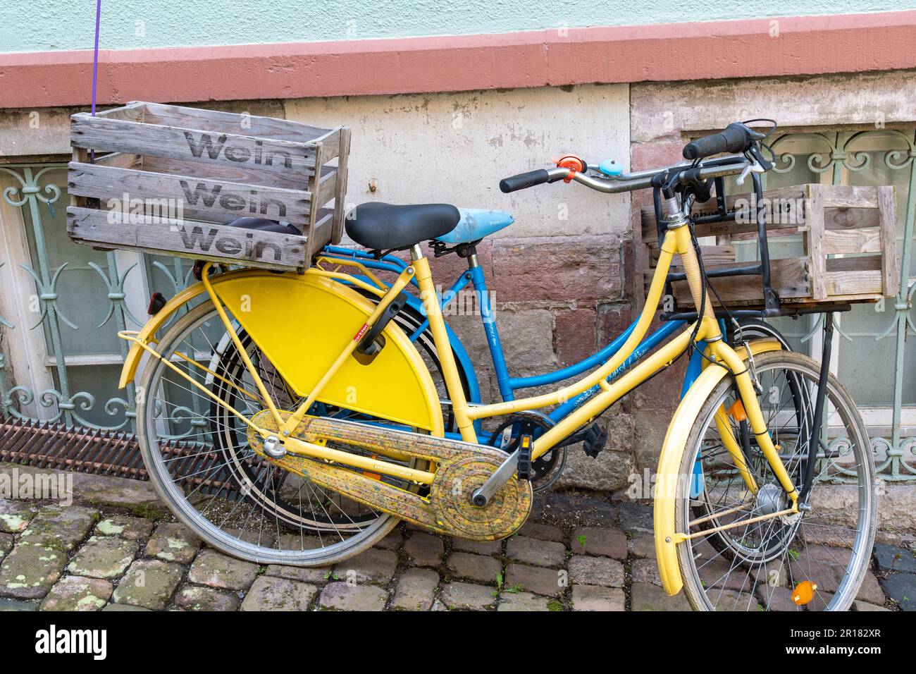 Two old vintage bicycles in yellow and blue with transport basket from ...