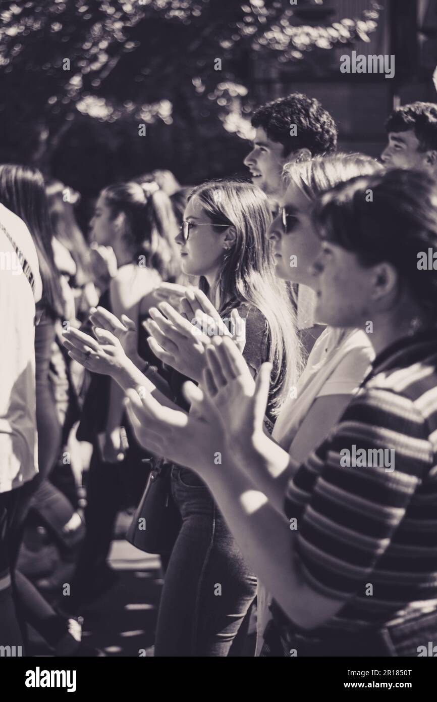 An outdoor crowd of people clapping in celebration in black and white ...