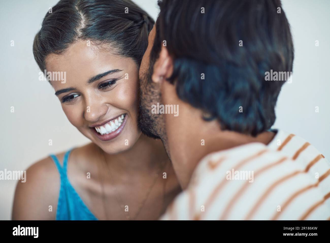 Whispering Sweet Nothings In Her Ear An Affectionate Young Couple Sharing A Kiss On Their Couch