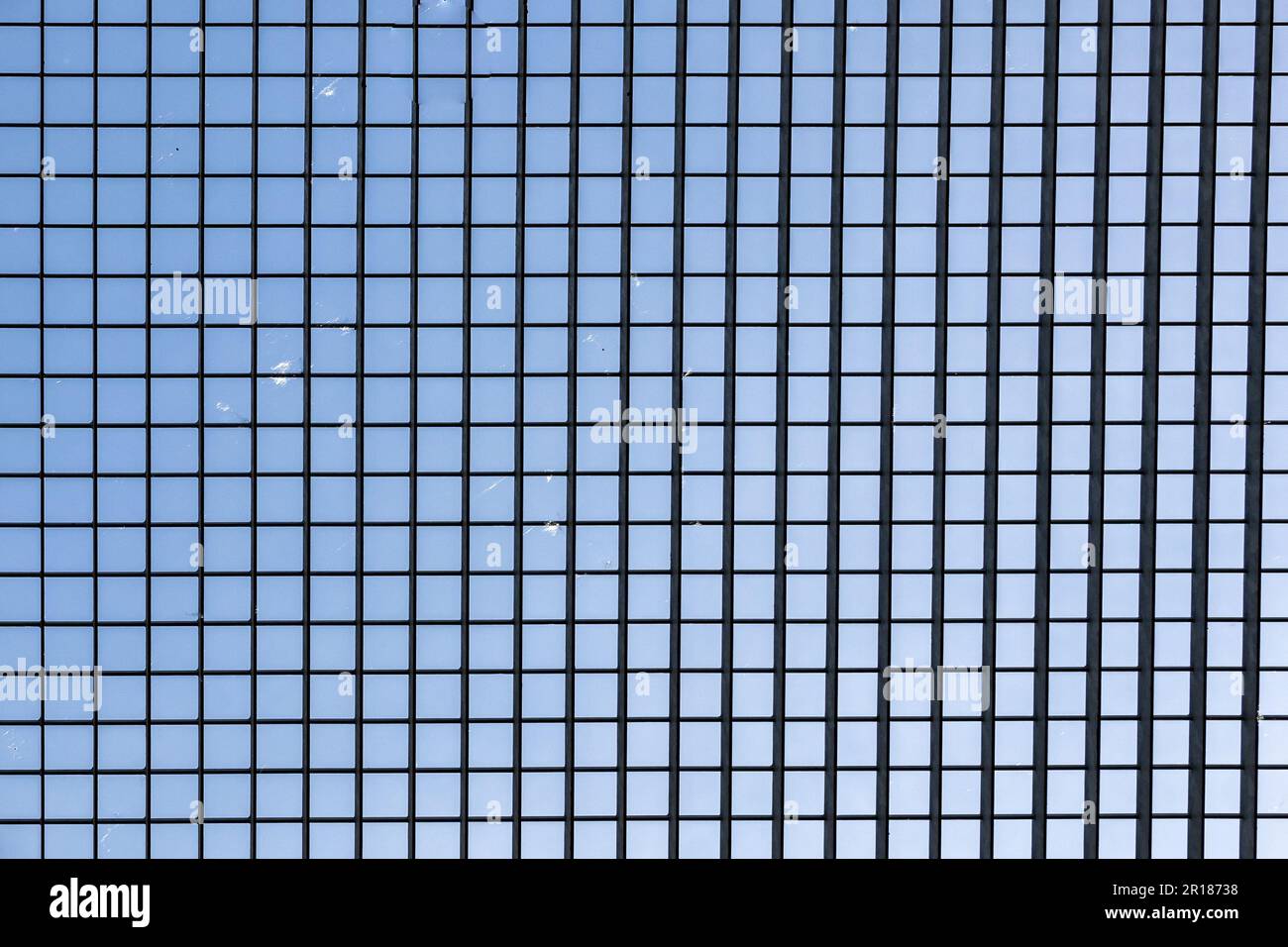Open metal grid on roof of a tunnel against blue sky, metal structure ...