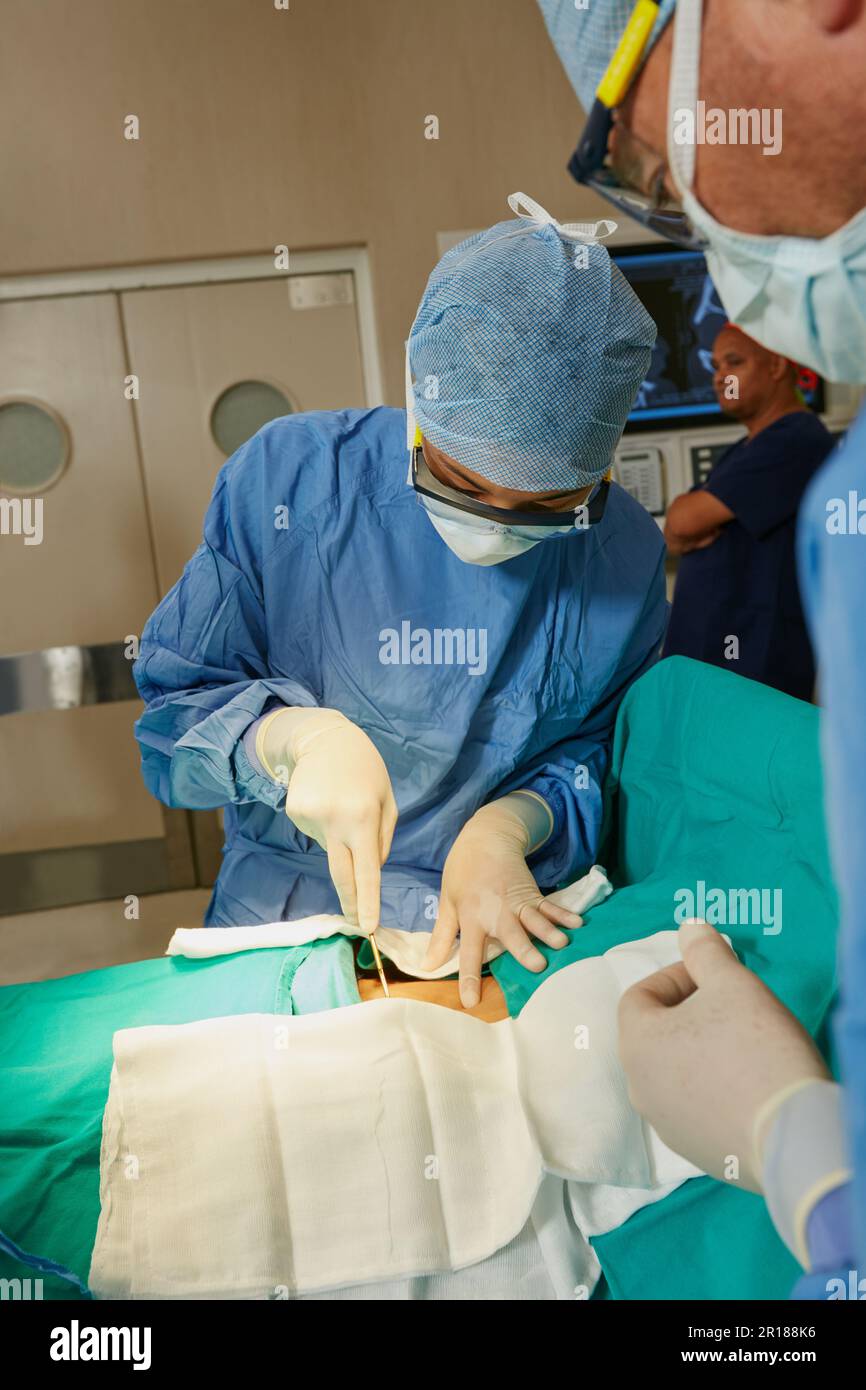 Dedicated life savers. a surgeon making an incision with a scalpel on a ...
