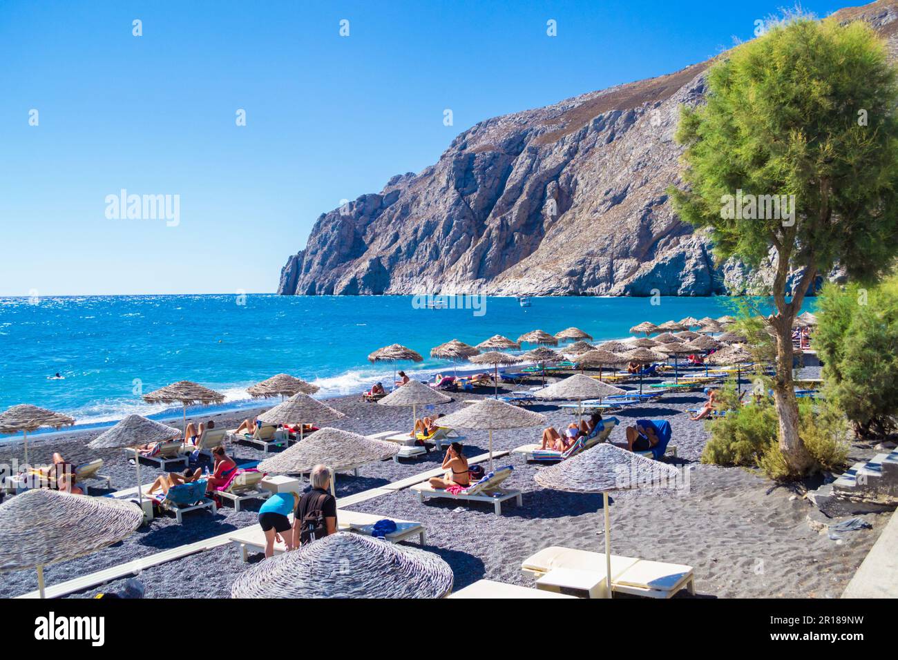 Alleys,loungers and reed umbrellas at the Black Beach of Kamari village ...