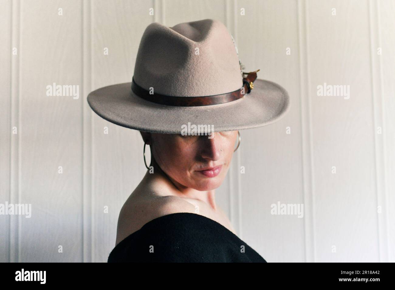 A white female wearing a large brimmed, fedora style had set against a ...