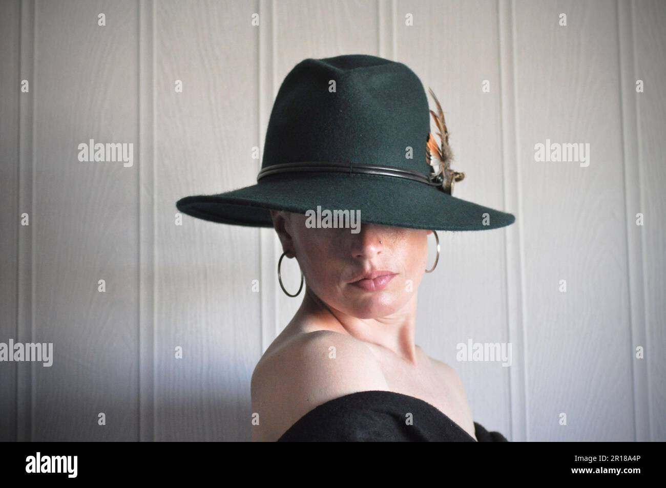 A white female wearing a large brimmed, fedora style had set against a ...