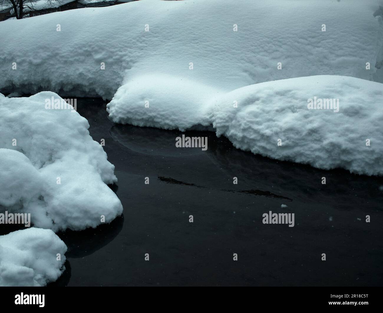 Snow piled up in creek Stock Photo - Alamy