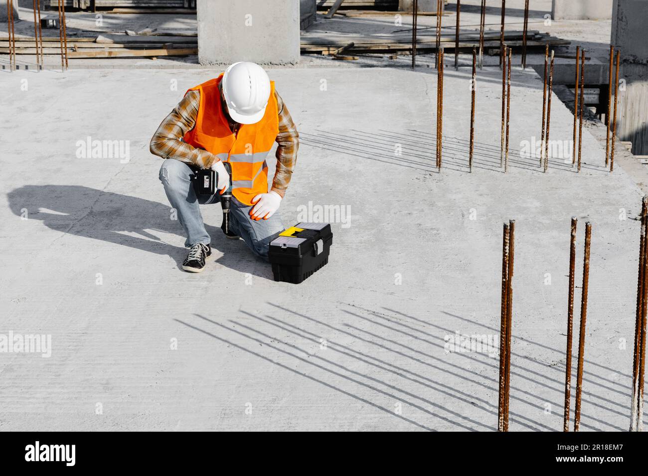 Repairman worker in uniform and helmet working with cordless ...