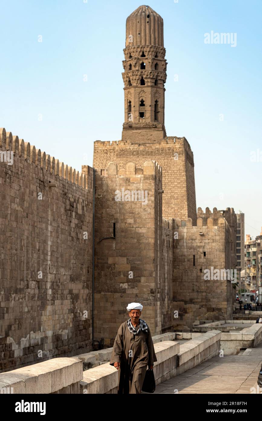 An Egyptian man wearing traditional clothes walking in front of the ...
