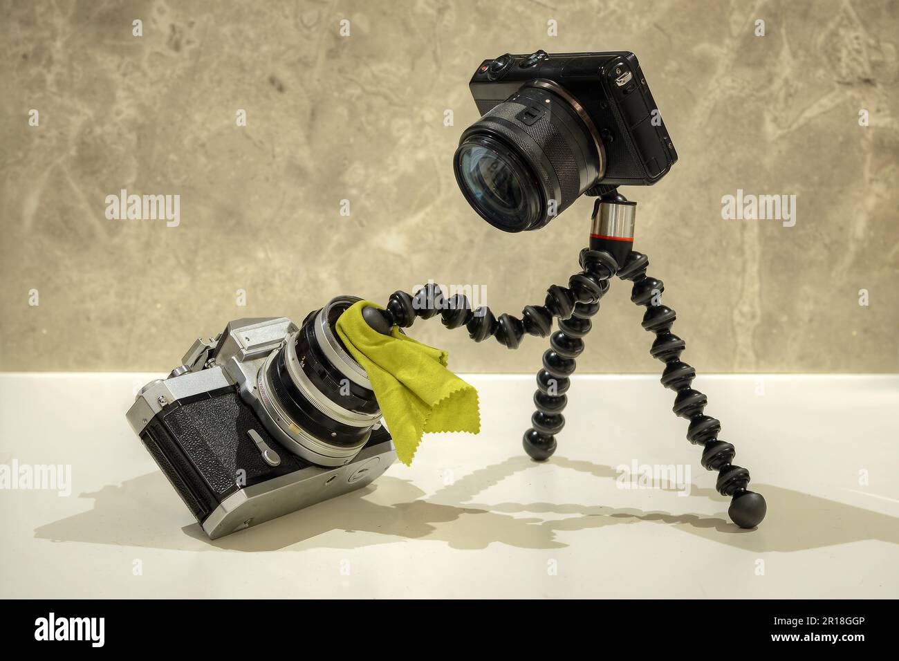 A small modern digital camera cleaning the lens of an old SLR film ...