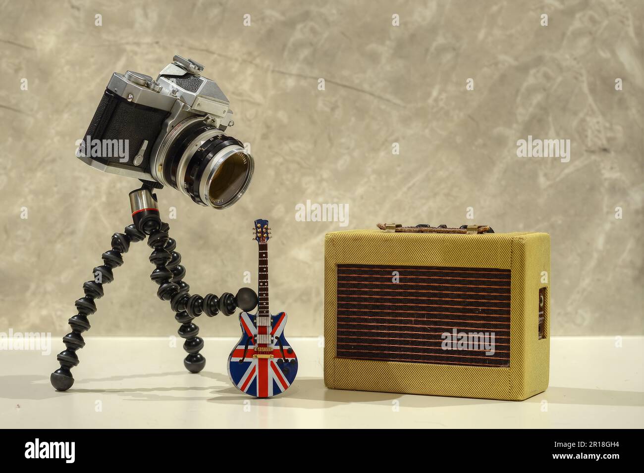 A photo of a camera playing electric guitar with a yellow amplifier on ...