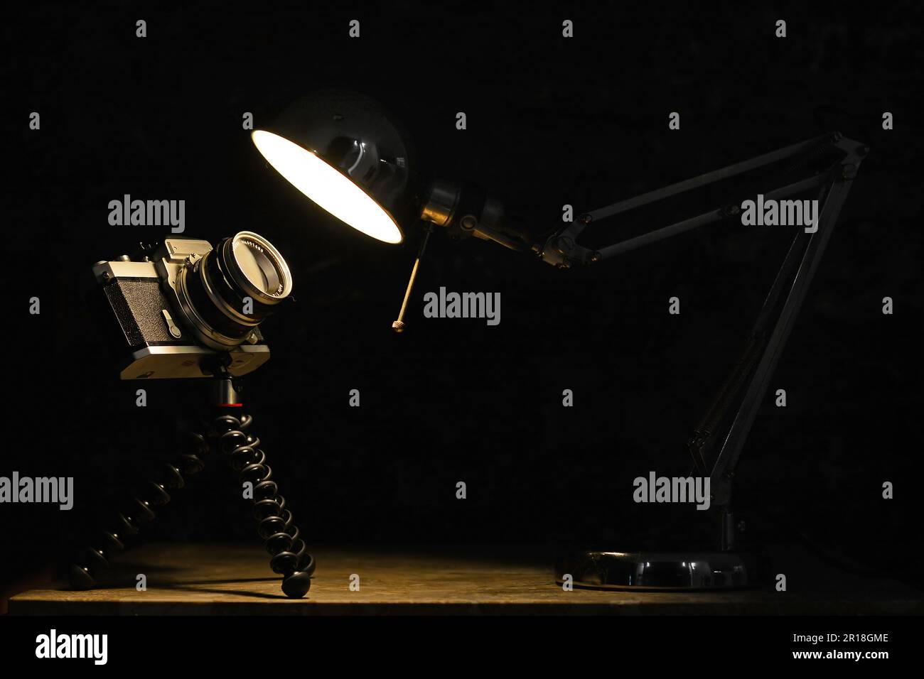 A photo of an old film metallic camera looking on a warm bulb Stock ...