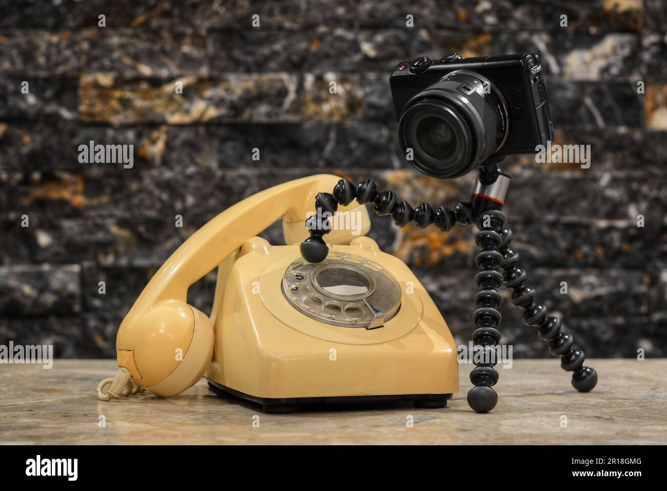 A small plastic modern mirror less camera using an old phone with ...