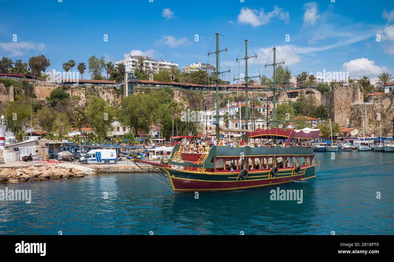 A tourist boat sails through the ancient harbour in Kaleici, the ...