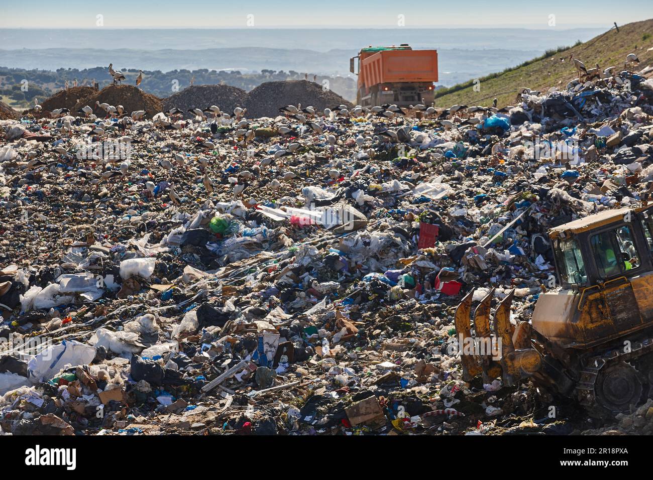 Heavy machinery shredding garbage in an open air landfill. Waste Stock ...