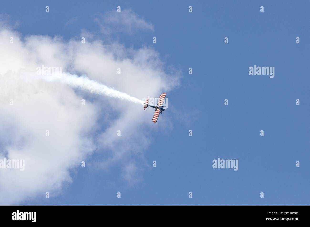 A blue plane with red and white stripes is performing acrobatics Stock ...