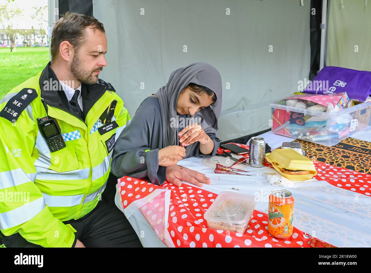 Artist applying henna tattoo on a Police Officer. Mehndi is traditional ...