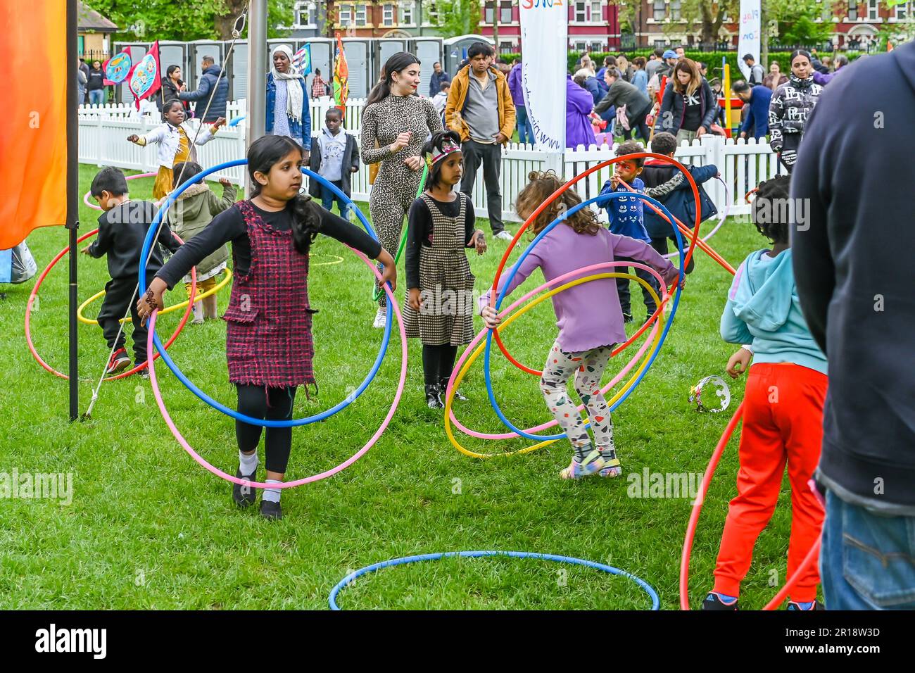 Children playing with hula hoop in festival Stock Photo - Alamy