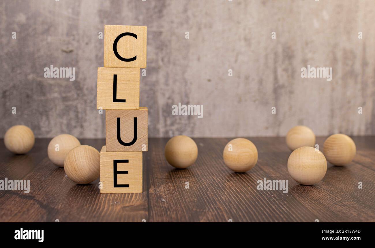 a pyramid of wooden cubes with the word CLUE and wooden balls around on ...