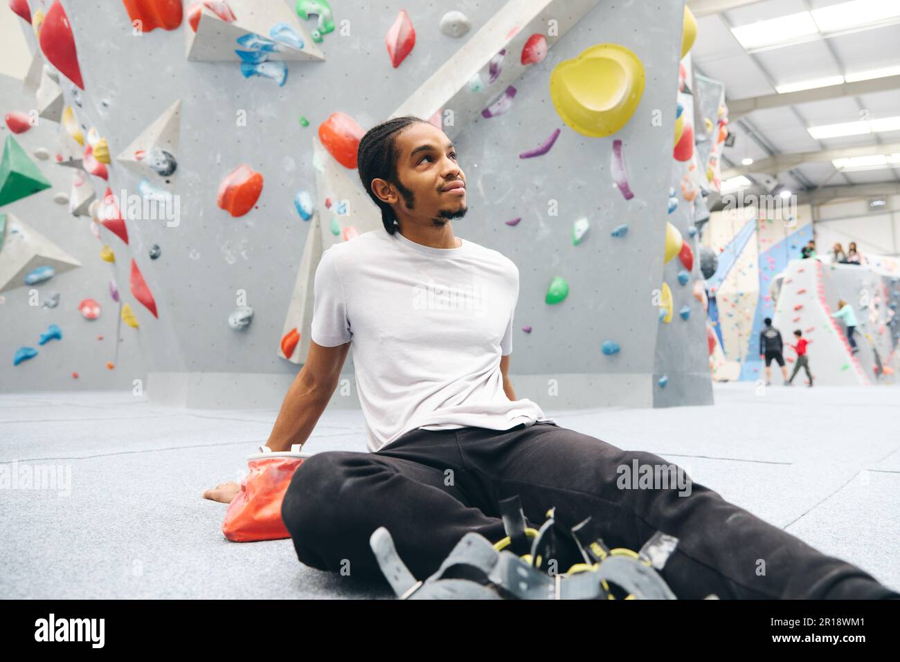 Man Sitting on Floor Excited To Try Climbing Wall At Indoor Centre ...