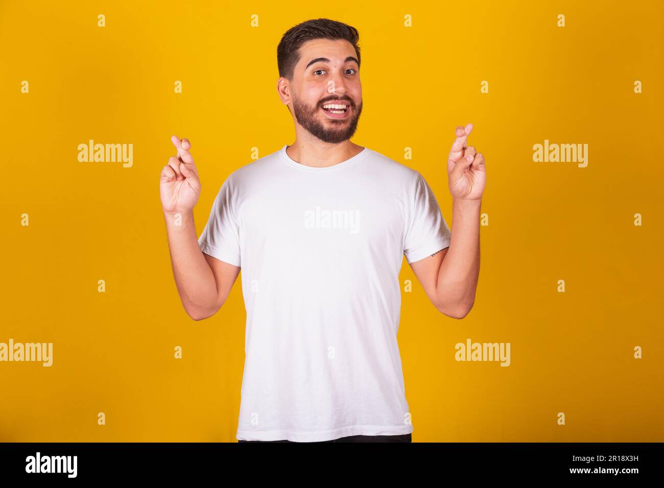 Brazilian Latin American man, fingers crossed, lucky sign, cheering ...