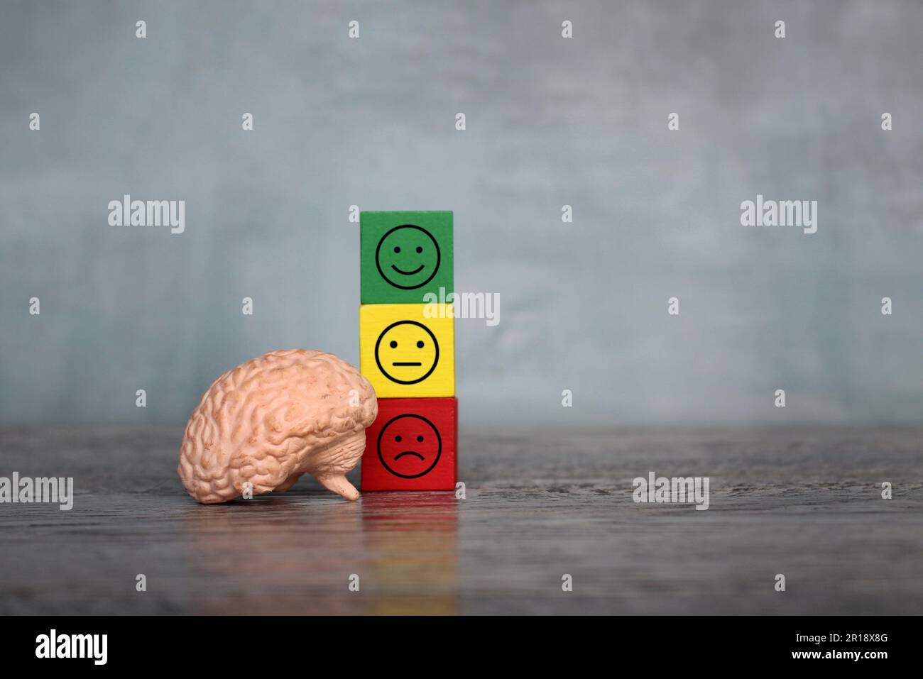 Brain and wooden cubes with happy, neutral and sad face. Mental health ...