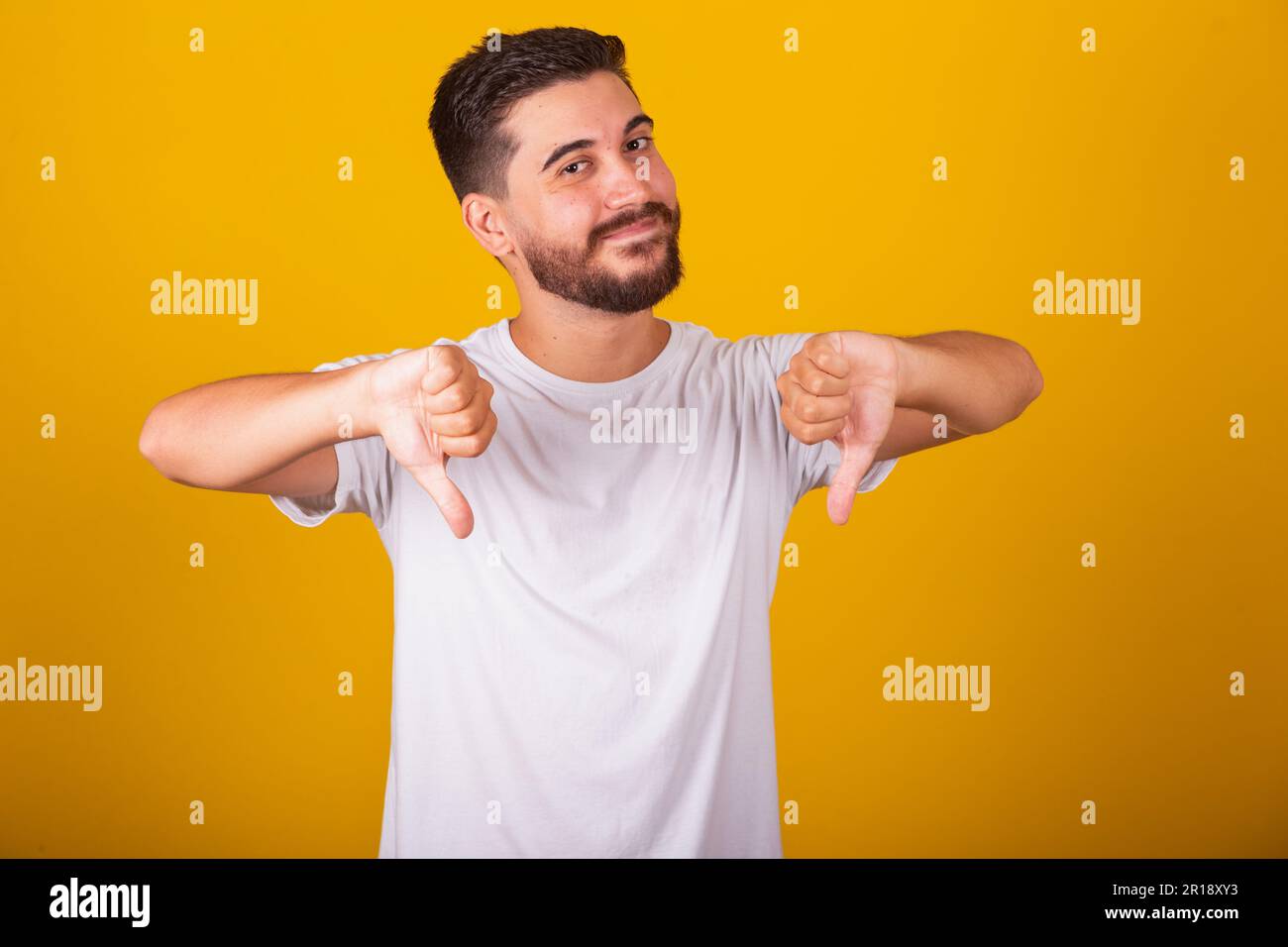 Brazilian Latin American man with thumbs down gesture indicating ...