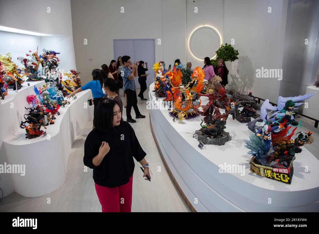 Visitors observe a collection of superhero statues at Statue4Heroes ...