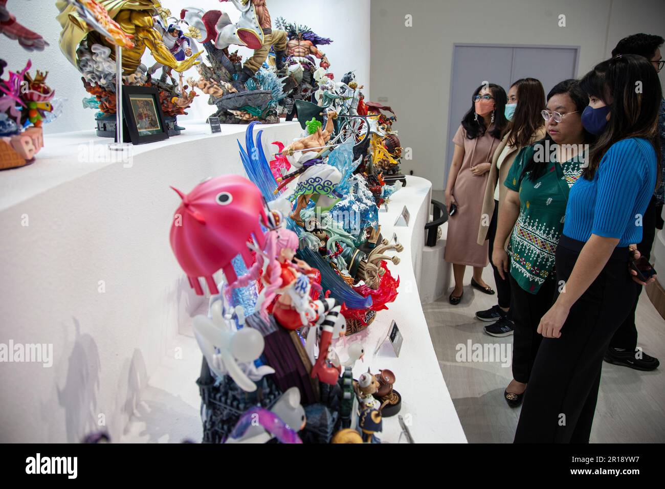 Visitors observe a collection of superhero statues at Statue4Heroes ...