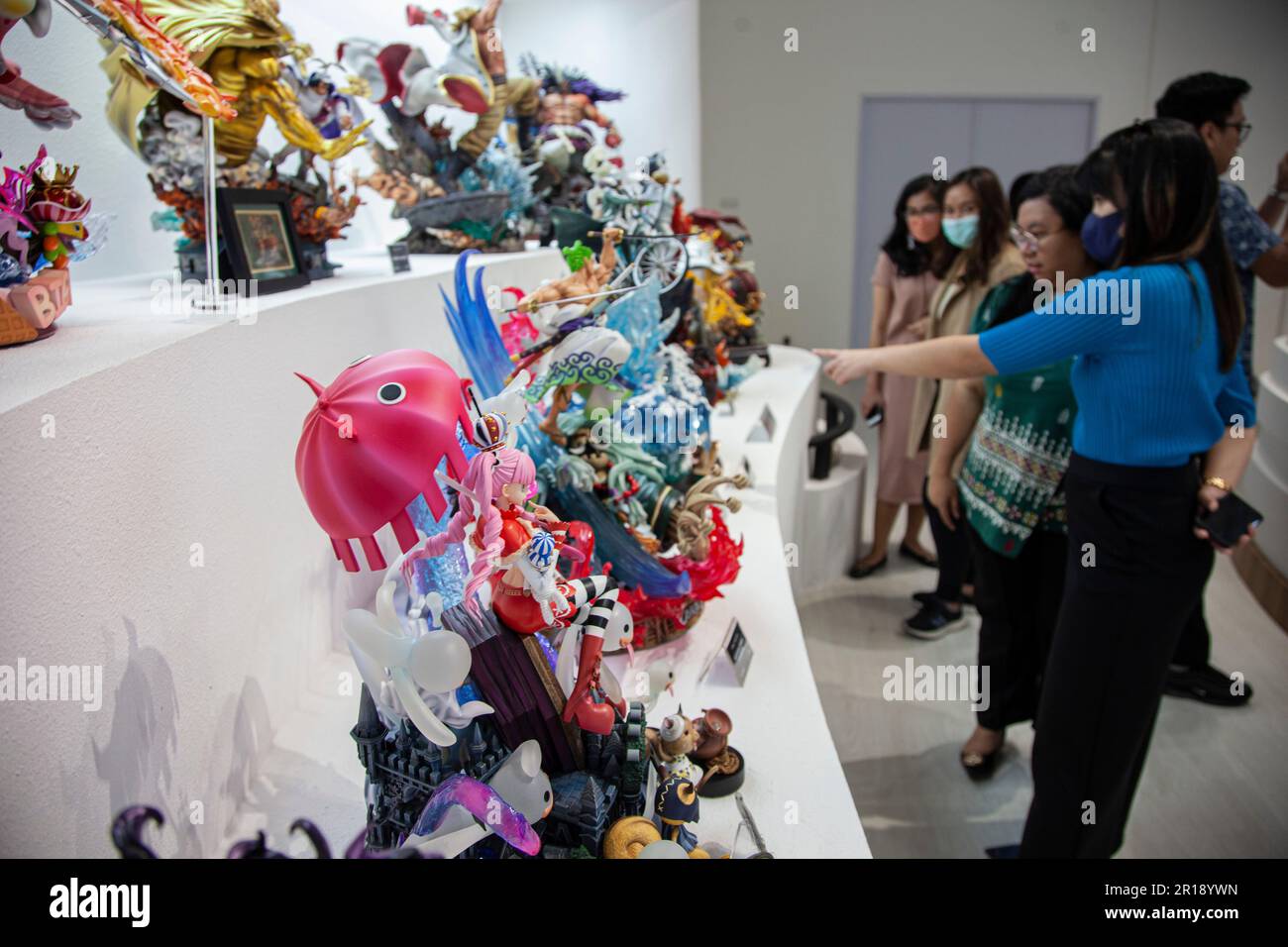 Visitors observe a collection of superhero statues at Statue4Heroes ...