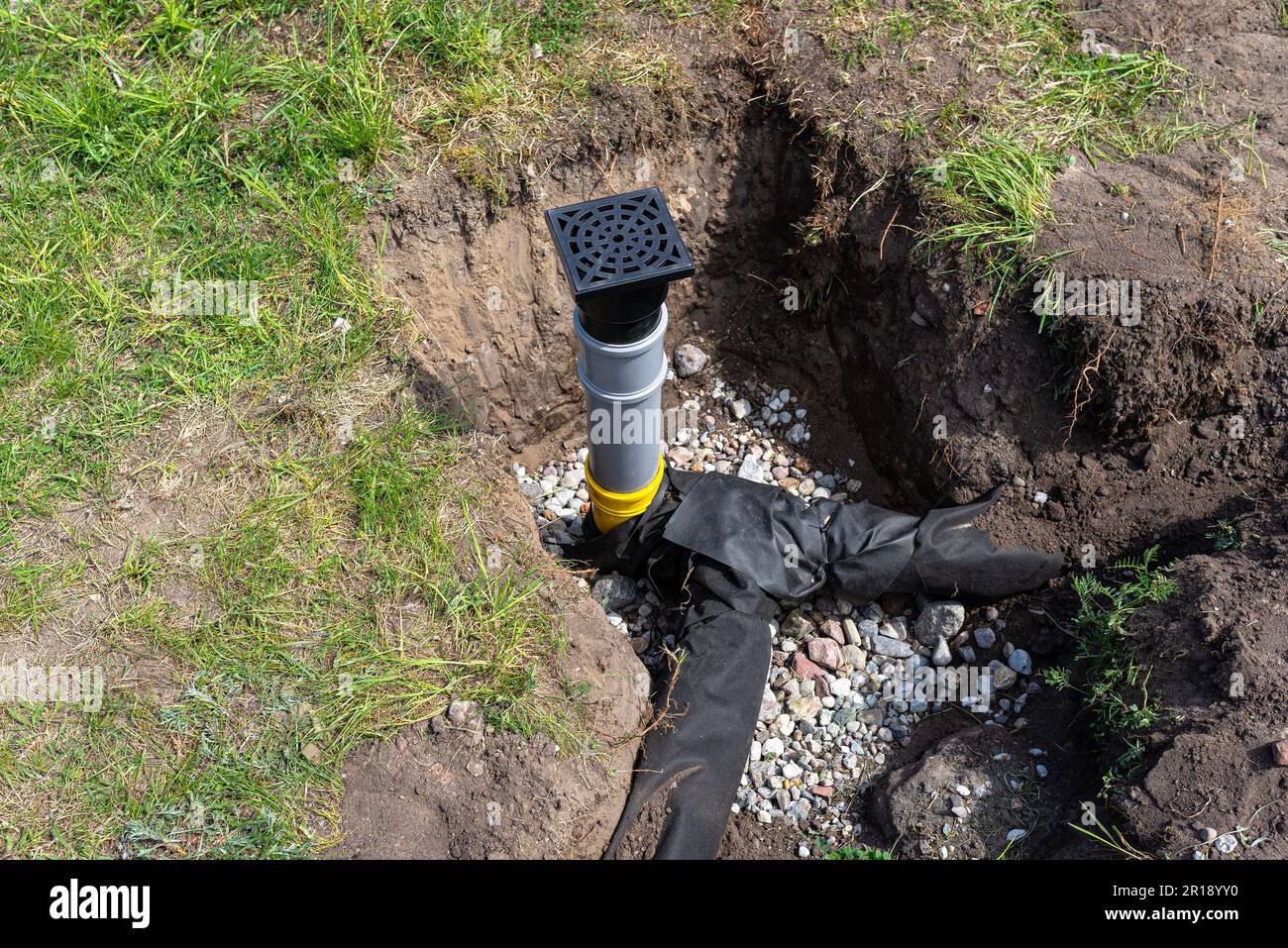 Overflow and infiltration well connected to drainage pipes, buried in a ...
