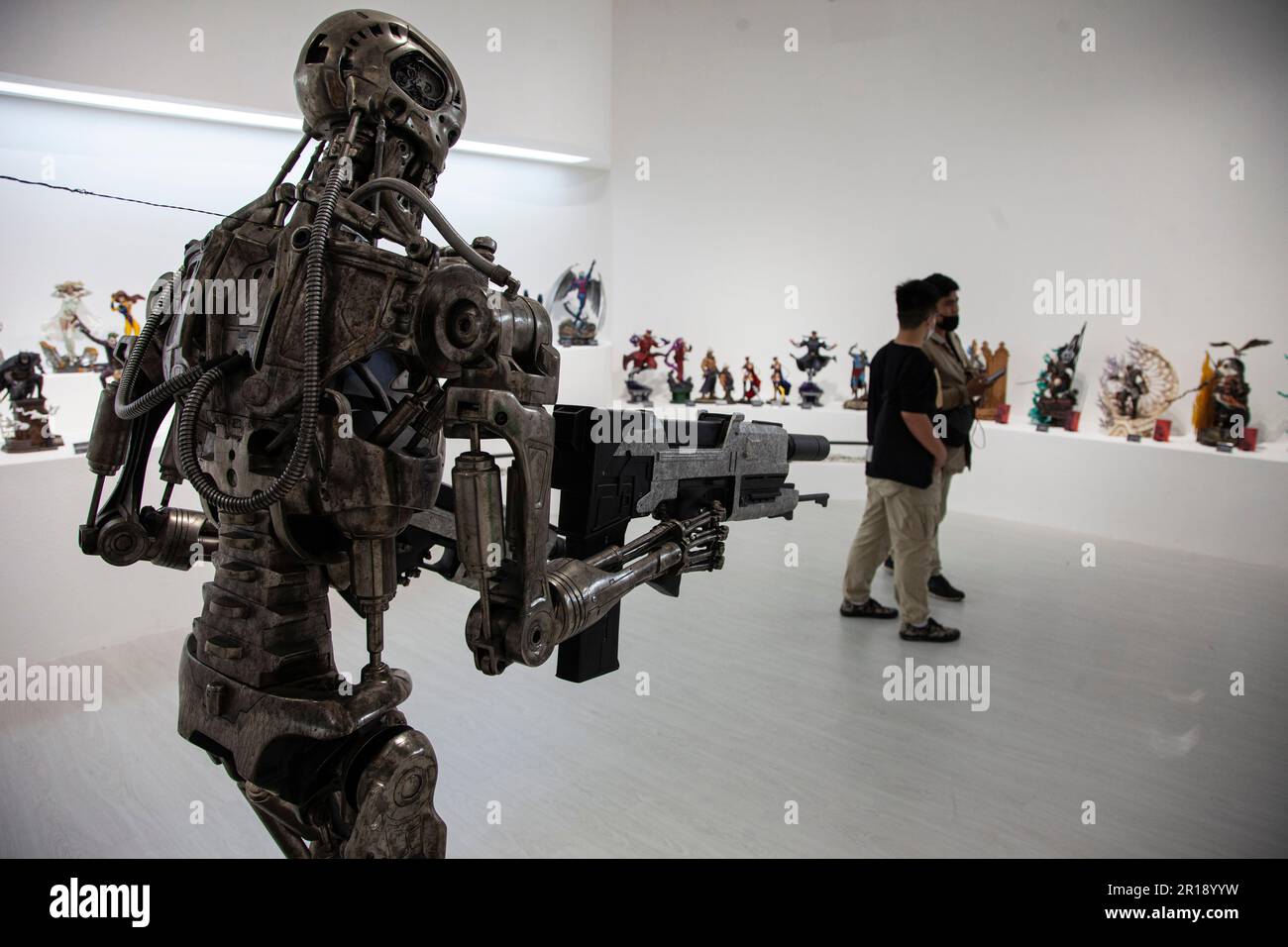 Visitors observe a collection of superhero statues at Statue4Heroes ...