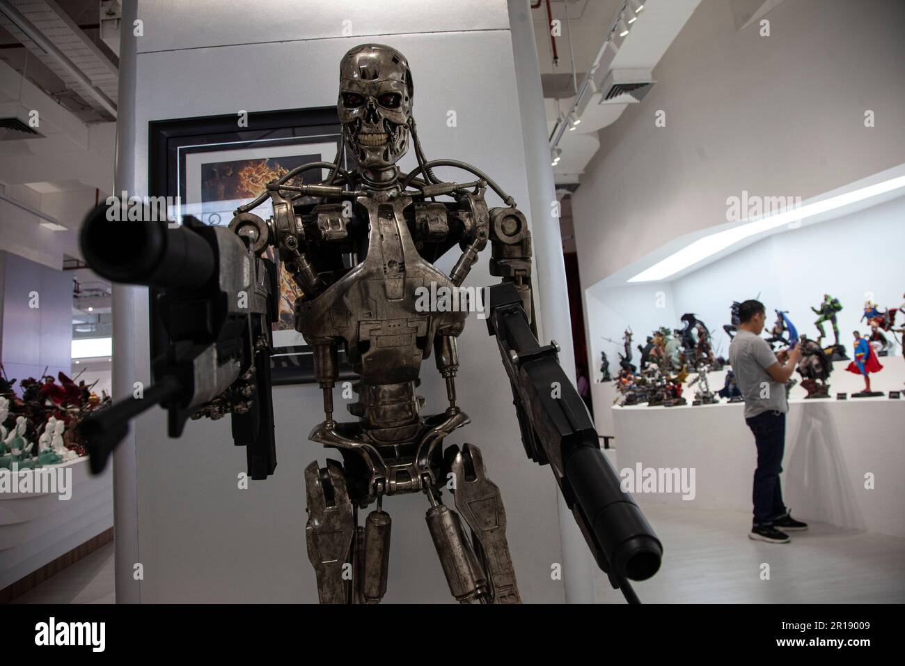 Visitors observe a collection of superhero statues at Statue4Heroes ...
